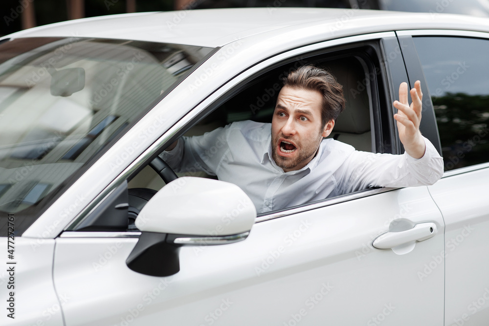 Angry driver stuck in traffic jam gesticulates with hand and screaming ...