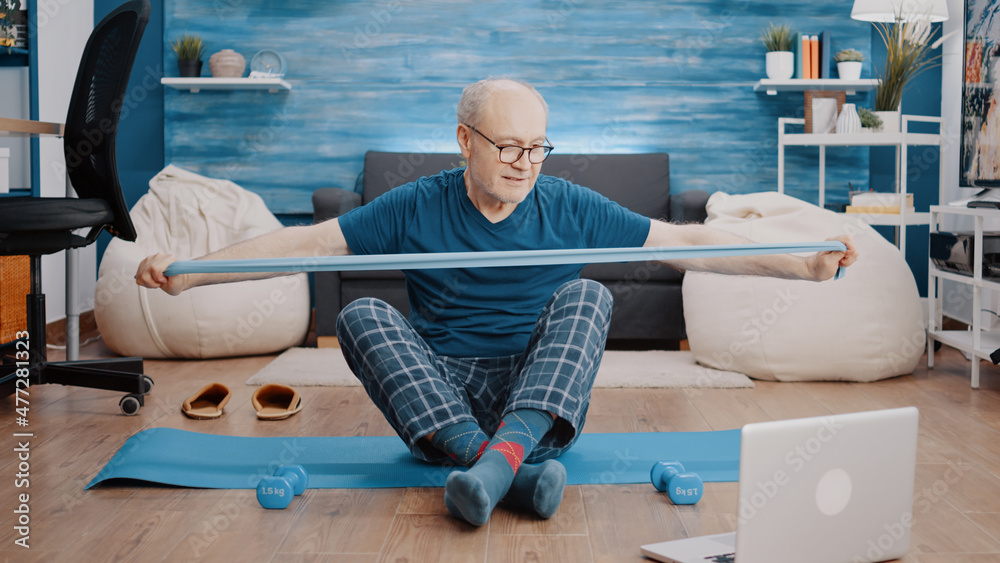 Senior person pulling flexible resistance band to exercise while ...