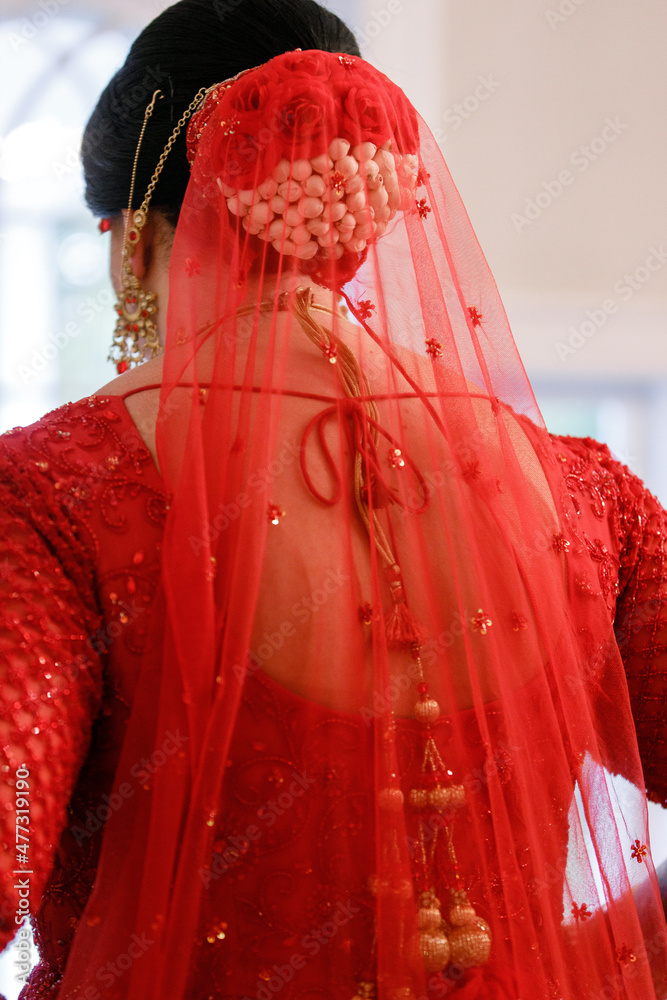 Look from behind at stunning Indian bride dressed in a red lehenga and ...