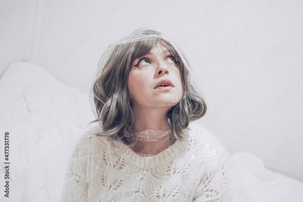 Woman wrapped in plastic looking up in confined space Stock Photo ...