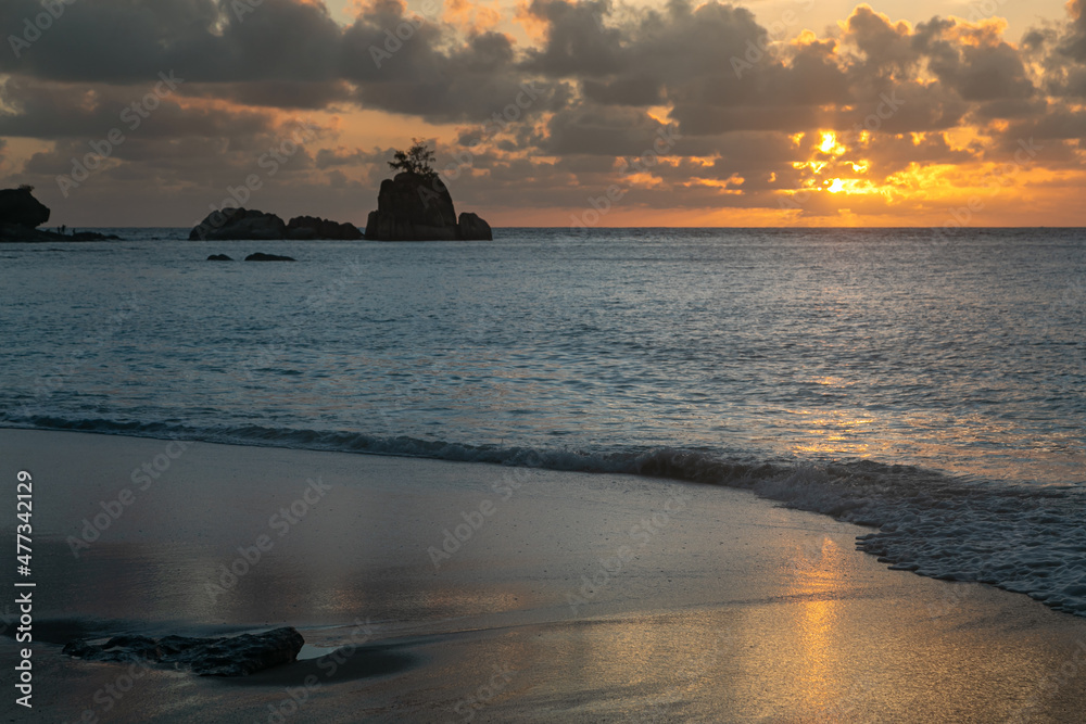 Tropical Sunset photo. Bright orange sun sinks behind the horizon and ...