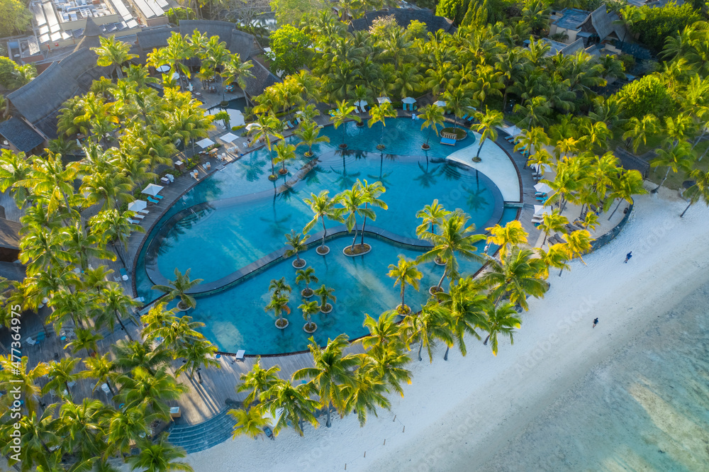 Aerial view of a beautiful swimming pool with palm trees in a luxury ...
