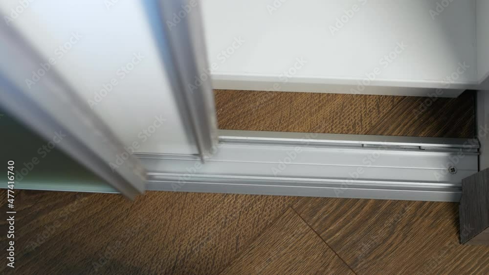 Installation of a door on aluminum rails with wheels close-up. Wardrobe ...
