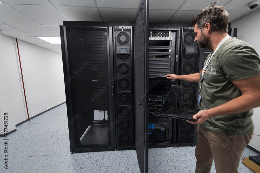 Data Center Engineer Usaing Keyboard on a Supercomputer Server Room ...