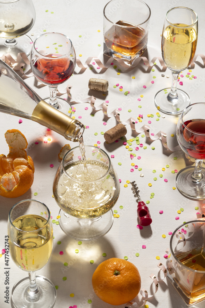 Fun party with alcoholic beverages. There are wine glasses with poured alcohol on white table ...