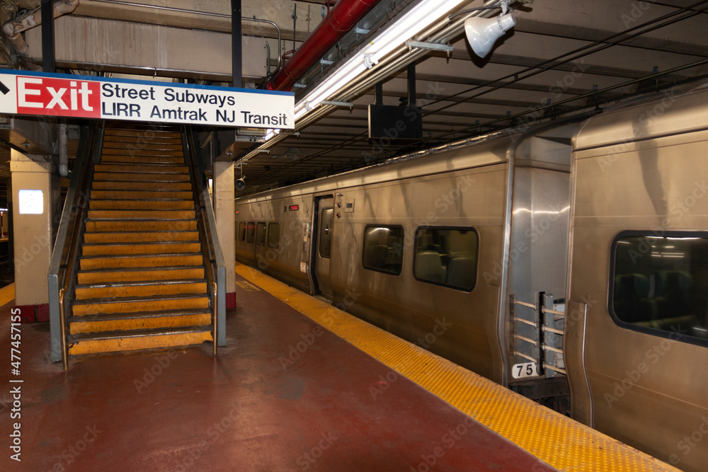 Train leaving LIRR Penn Statiion passing the exit sign staircase ...