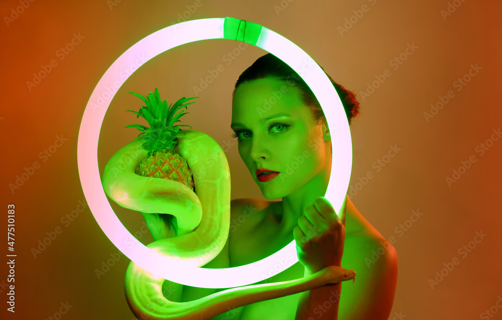 A beautiful young woman poses nude for the camera. She holds a ...