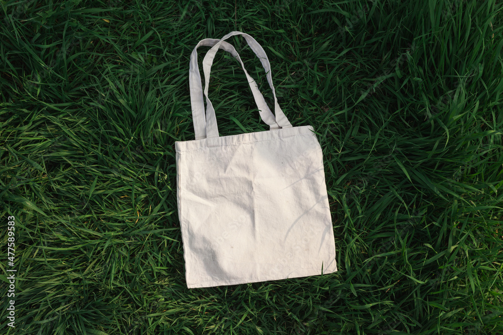 White cotton or mesh eco bag on green grass background. Zero waste, no ...