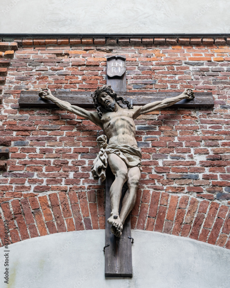 Stone sculpture of the crucifixion of Jesus Christ on the brick facade ...