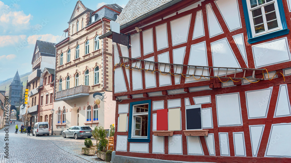 view of a stone-paved street with a beautiful half-timbered house in ...