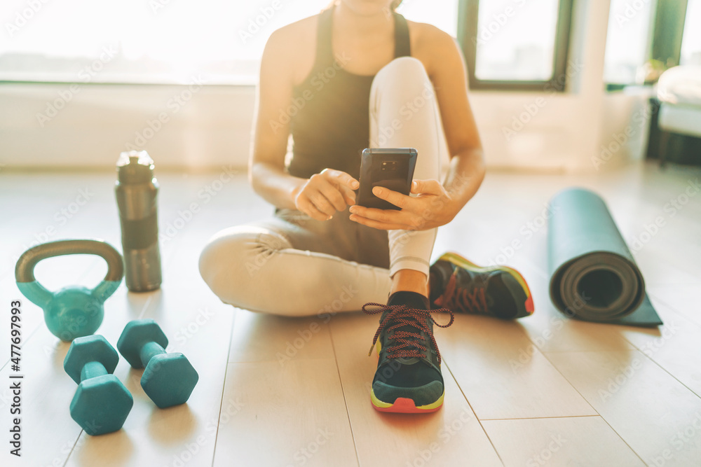 Fitness app on mobile phone for exercise at home. Woman using tech ...