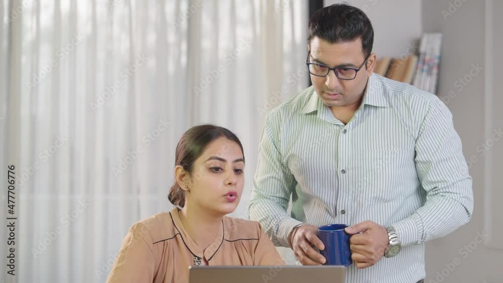 Young Indian Asian male senior corporate employee assisting his junior ...