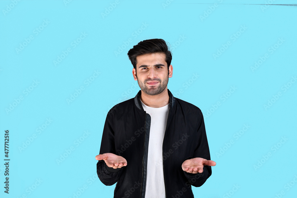 Young man front pose wearing winter clothes on blue background indian ...