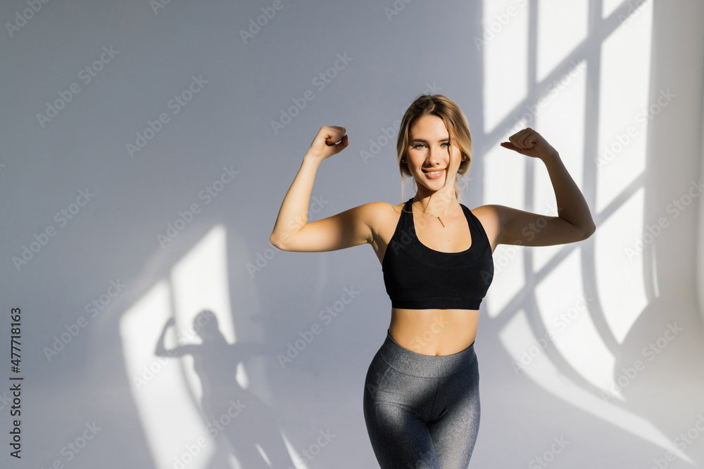 Beautiful strong muscular woman flexing her biceps and arm muscles ...