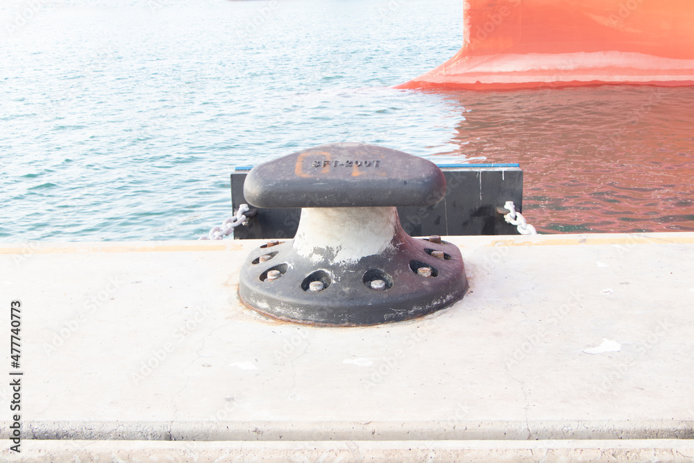 Sturdy metal mooring bollard at pier big lack attached to concrete ...