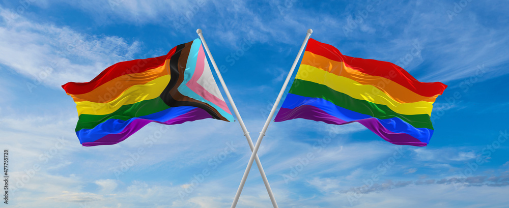crossed flags of progress lgbt pride and LGBT Pride flag waving in the ...