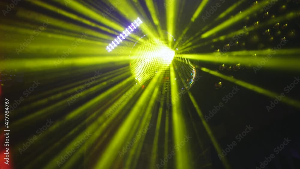 Rays of light reflecting from the disco ball, illuminate the smoke ...