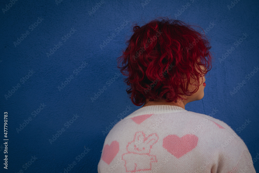 Joven con cabello rojo y sueter de corazones rosas y colores pastel ...