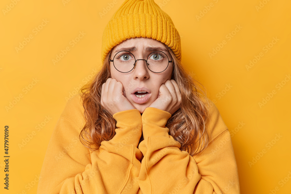 Portrait of embarrassed shocked young woman stares nervous keeps hands ...