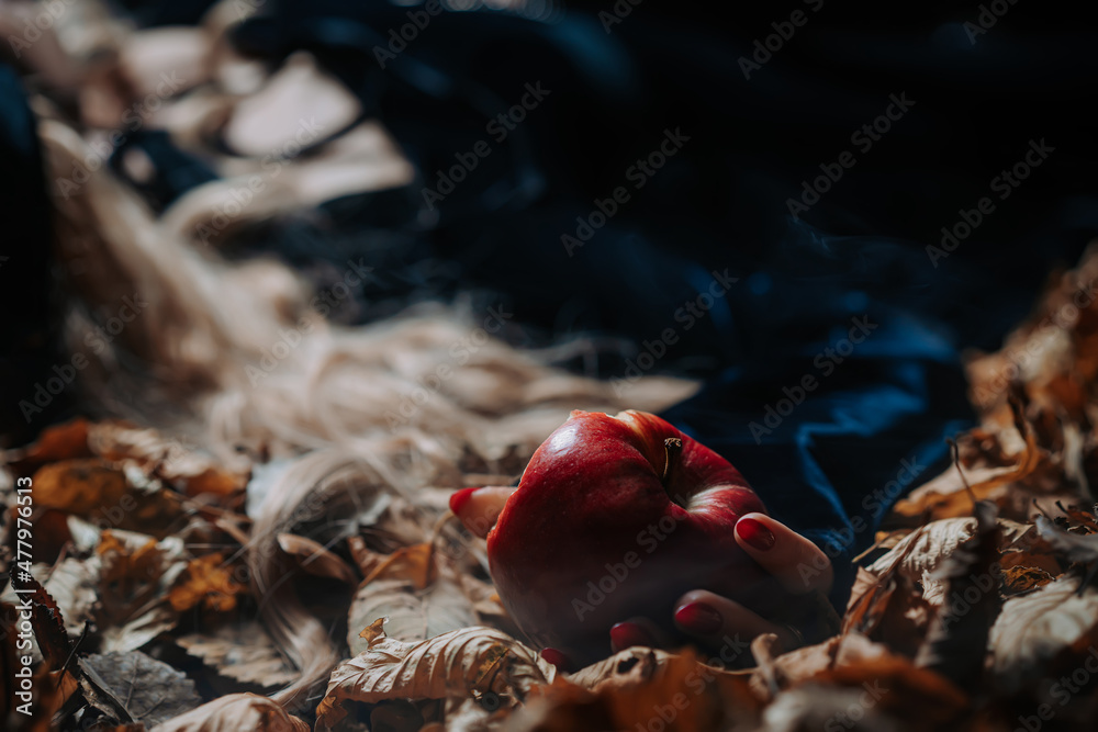Woman snow white poisoned by apple lies on ground in forest. Symbol of ...