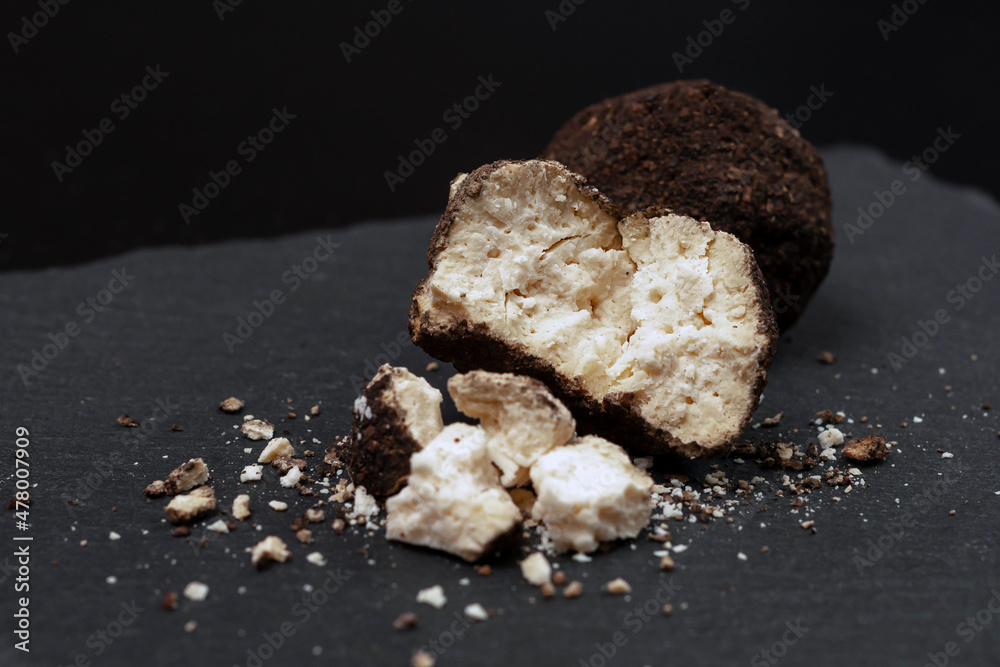 side view of a whole and broken ball of Belper Knoll cheese lying on a ...
