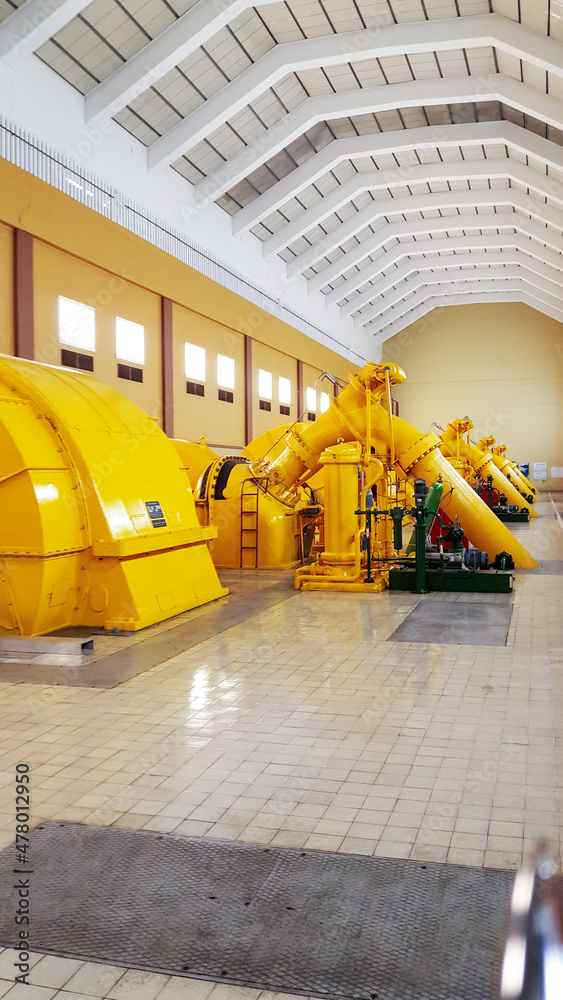 Yellow turbines in machine hall inside power station. Hydro power ...
