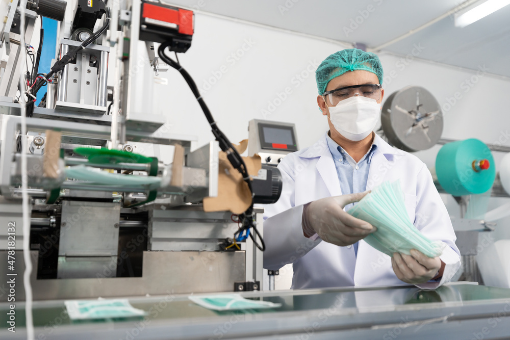 male factory worker are producing medical face masks, counting and ...