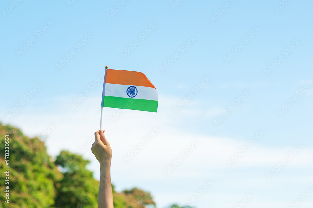 hand holding India flag on blue sky background. Holiday of India ...