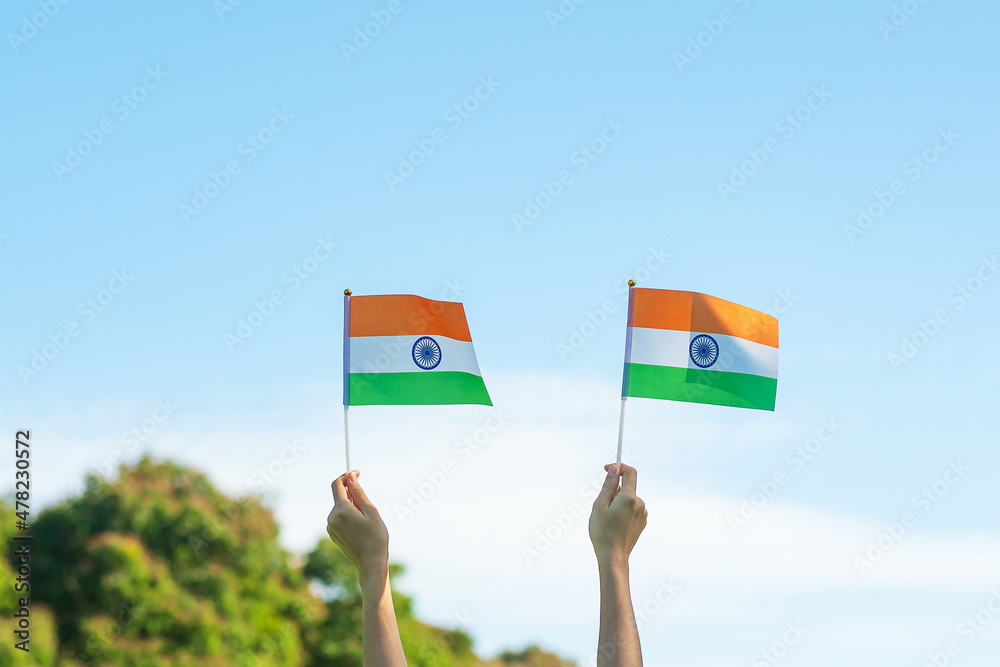 hand holding India flag on blue sky background. Holiday of India ...