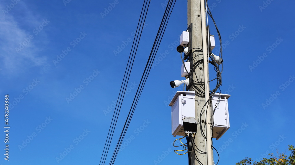 Surveillance cameras on electric poles. CCTV camera with control box on ...