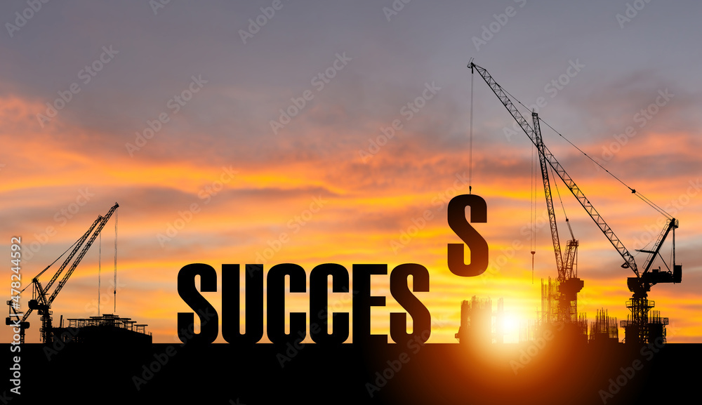 Silhouette of Success on construction site with crane and sunset sky ...