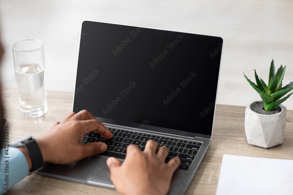 Young african american guy typing on pc with blank screen at workplace ...