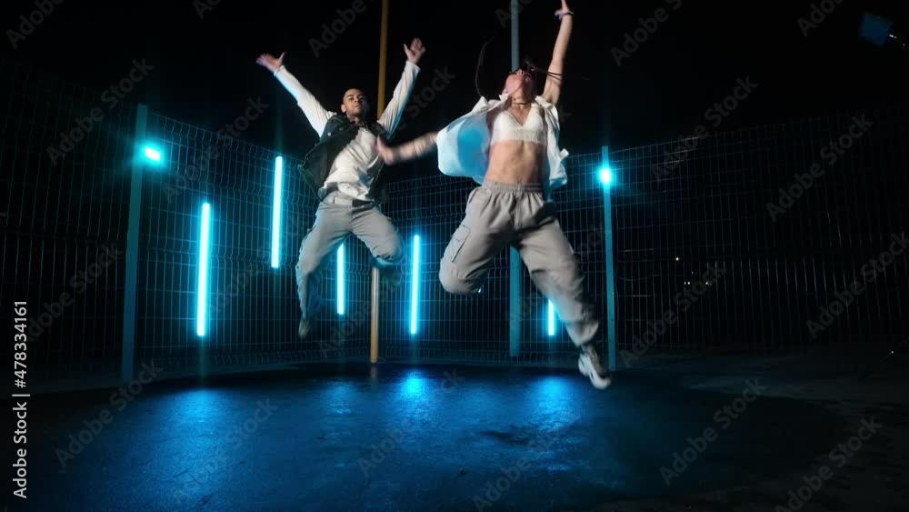 Duet of dancers performing afro dance at night with lightstands at ...