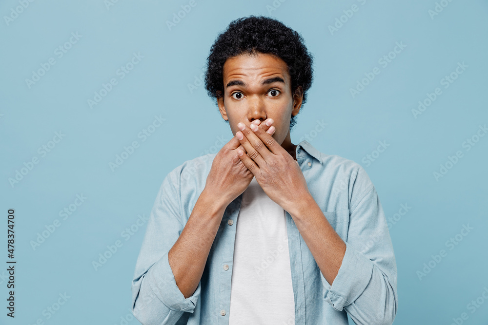 Shocked surprised startled stupefied impressed amazed afraid young black curly man 20s years old ...