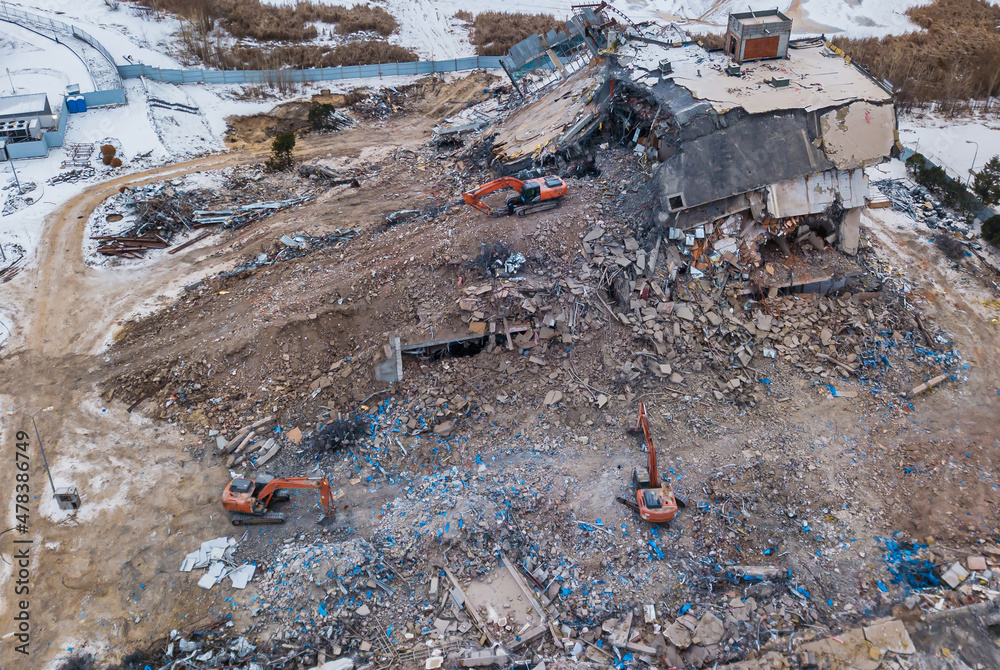 Heavy equipment being used to tear tearing down building construction ...