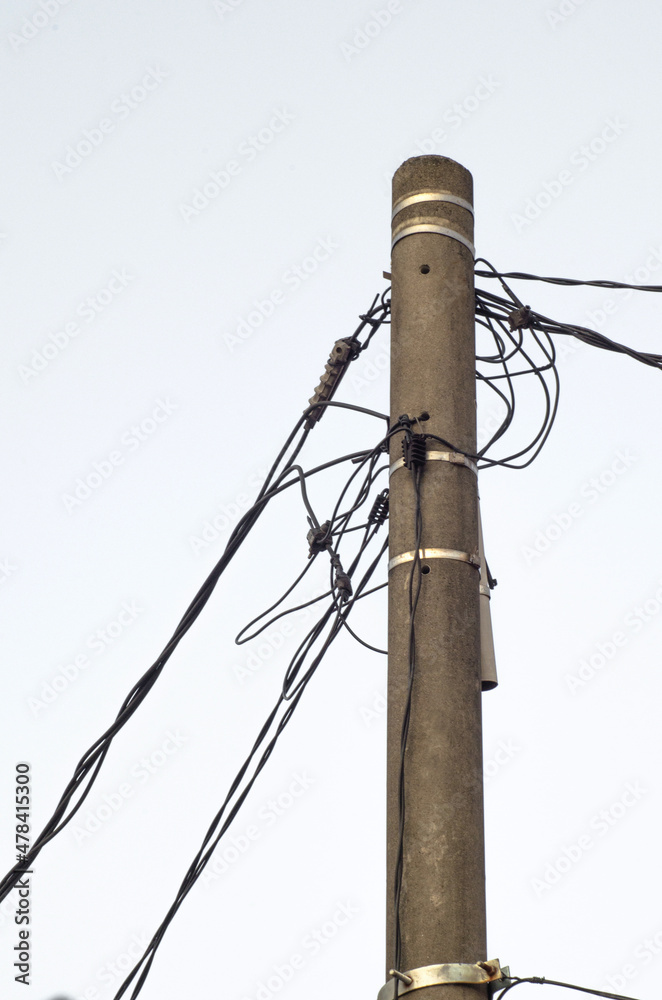 Round gray concrete power poles with transverse metal holder structure ...