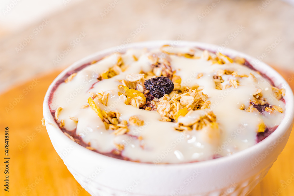 Açaí. Um açaí congelado com leite condensado e granola em uma tigela ...