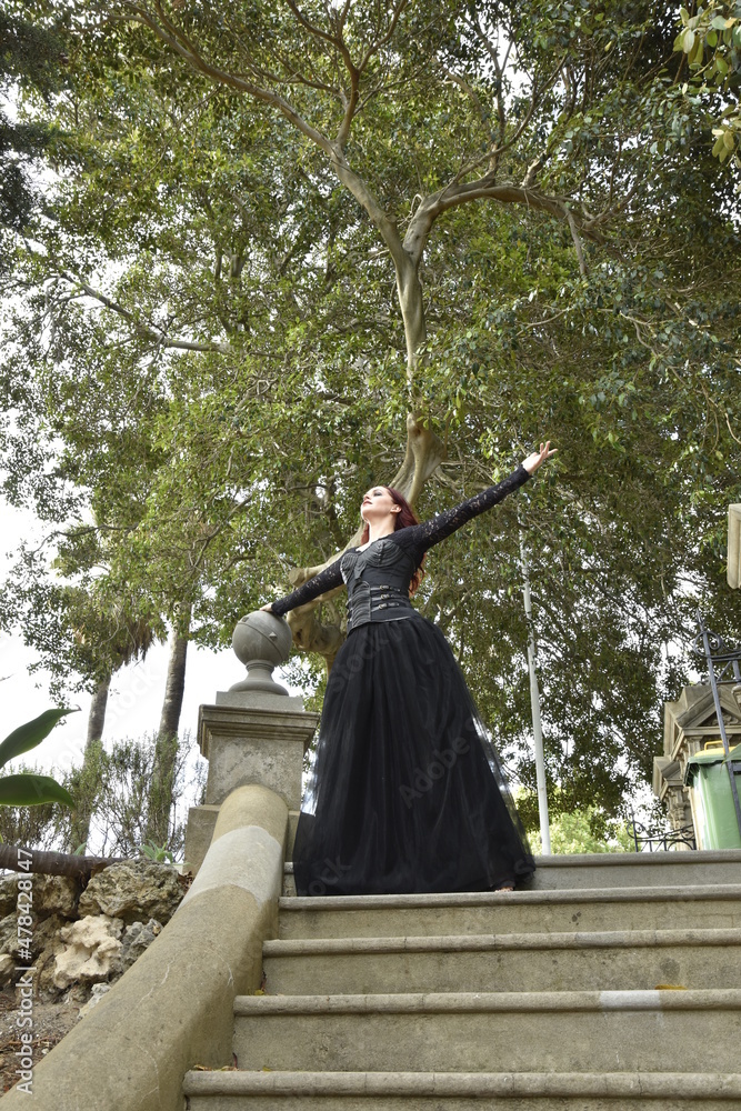 portrait of pretty female model with red hair wearing glamorous gothic ...
