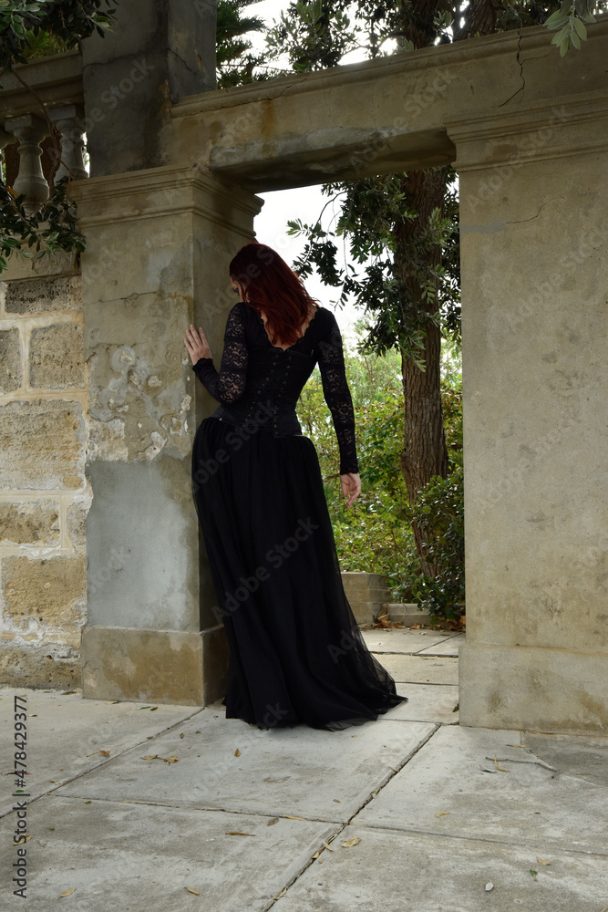 portrait of pretty female model with red hair wearing glamorous gothic ...