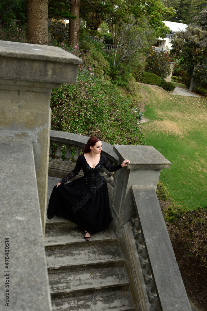portrait of pretty female model with red hair wearing glamorous gothic ...