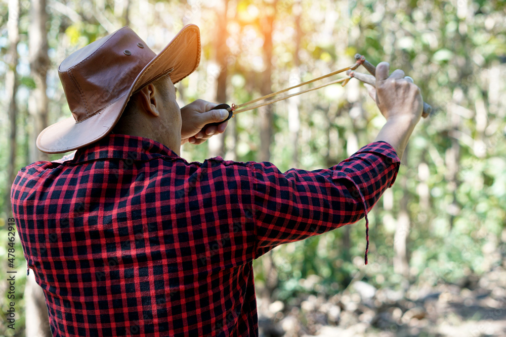 Asian man shooting a slingshot to shoot seeds into the forest Concept ...