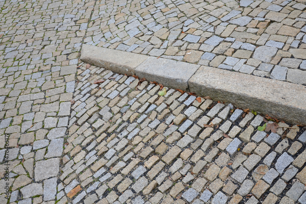 paving composed of different types of stone cubes and tiles stacked in ...