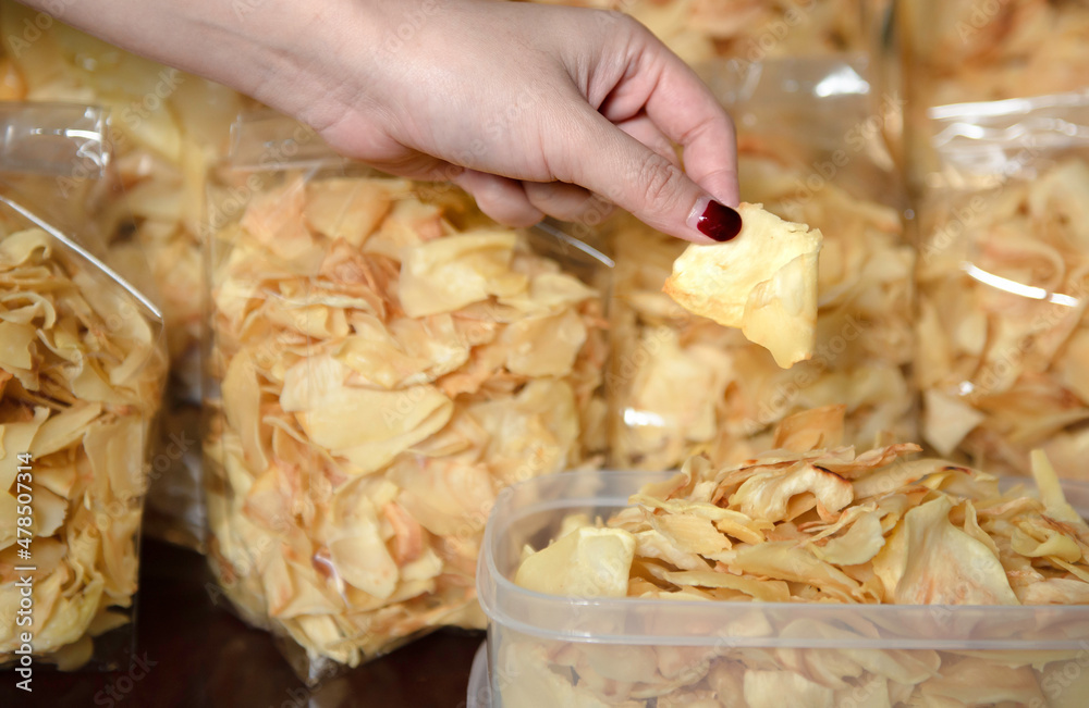 Fried durian chips. Woman's hand holding crispy durian chips, Famous ...