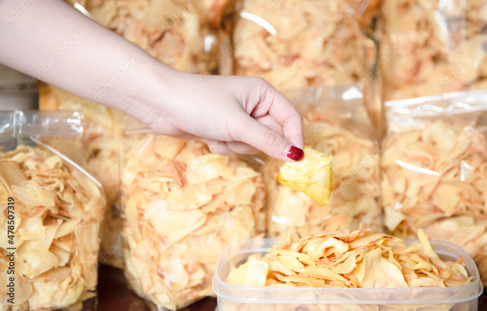 Fried durian chips. Woman's hand holding crispy durian chips, Famous ...