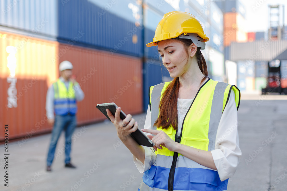 Women worker use tablet in uniform wearing safety helmet using laptop ...