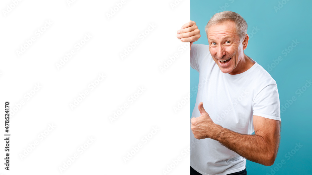 Mature man peeking out blank white advertising billboard showing like ...