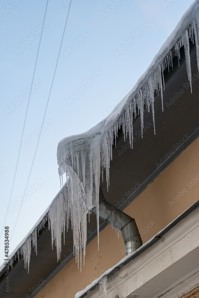 Foto de Big frozen icicles dangerously hanging from building edge on ...
