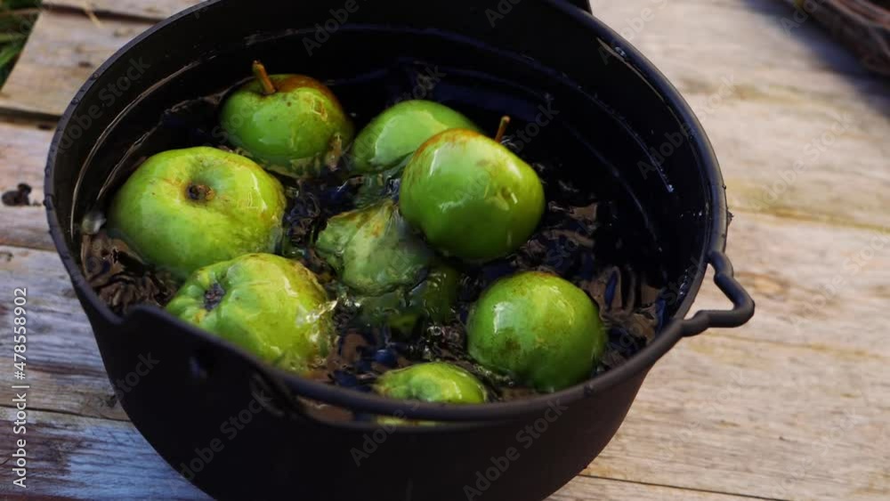 Throwing apples into a cauldron for bobbing at Halloween Stock Video ...