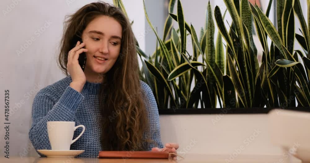 Pretty young girl flirtatiously communicates on the phone and laughs ...