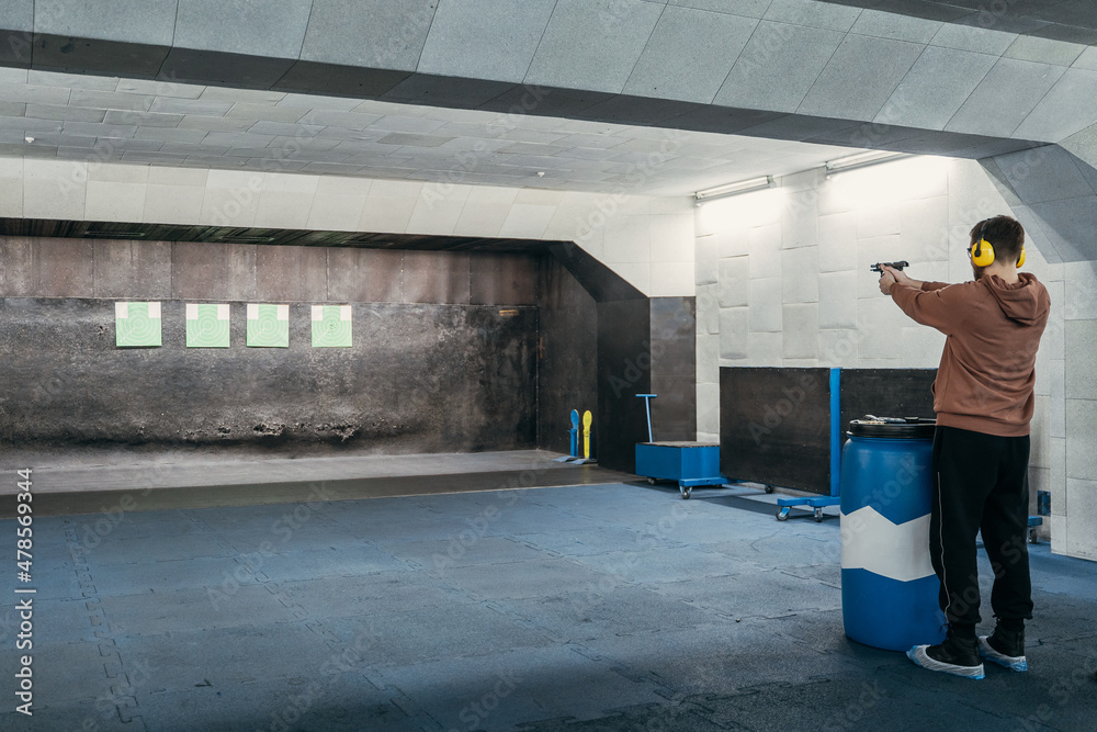 Long range shooting in a shooting range. A man shoots a short-barreled ...